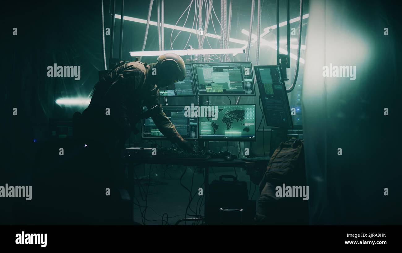Police tactical unit with guns checking computers and desk in dark room ...