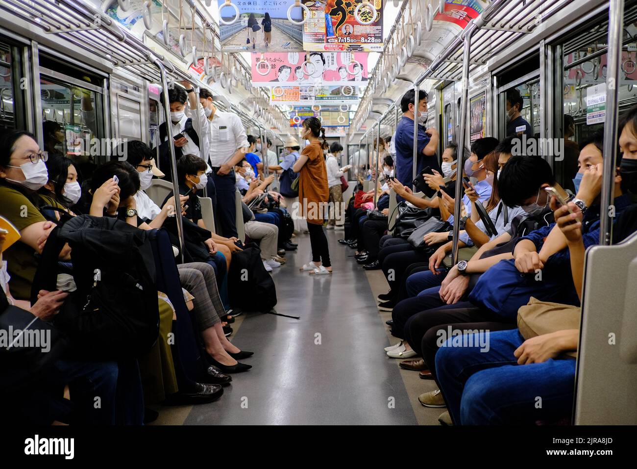 Commuters wearing face masks as a preventive measure against the spread ...