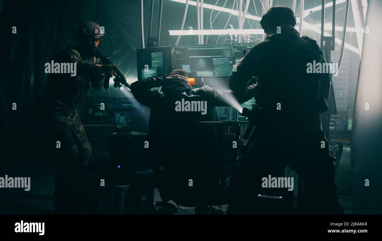 Tactical team in armor breaking into dark room and putting handcuffs on ...