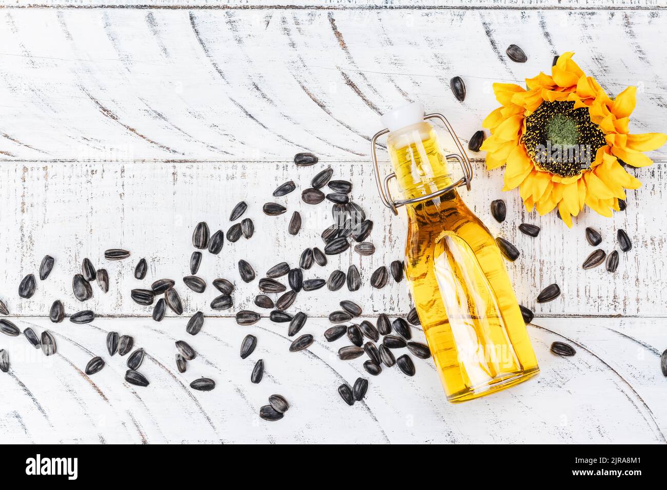 Golden unrefined sunflower oil, sunflower seeds and flowers on summer ...