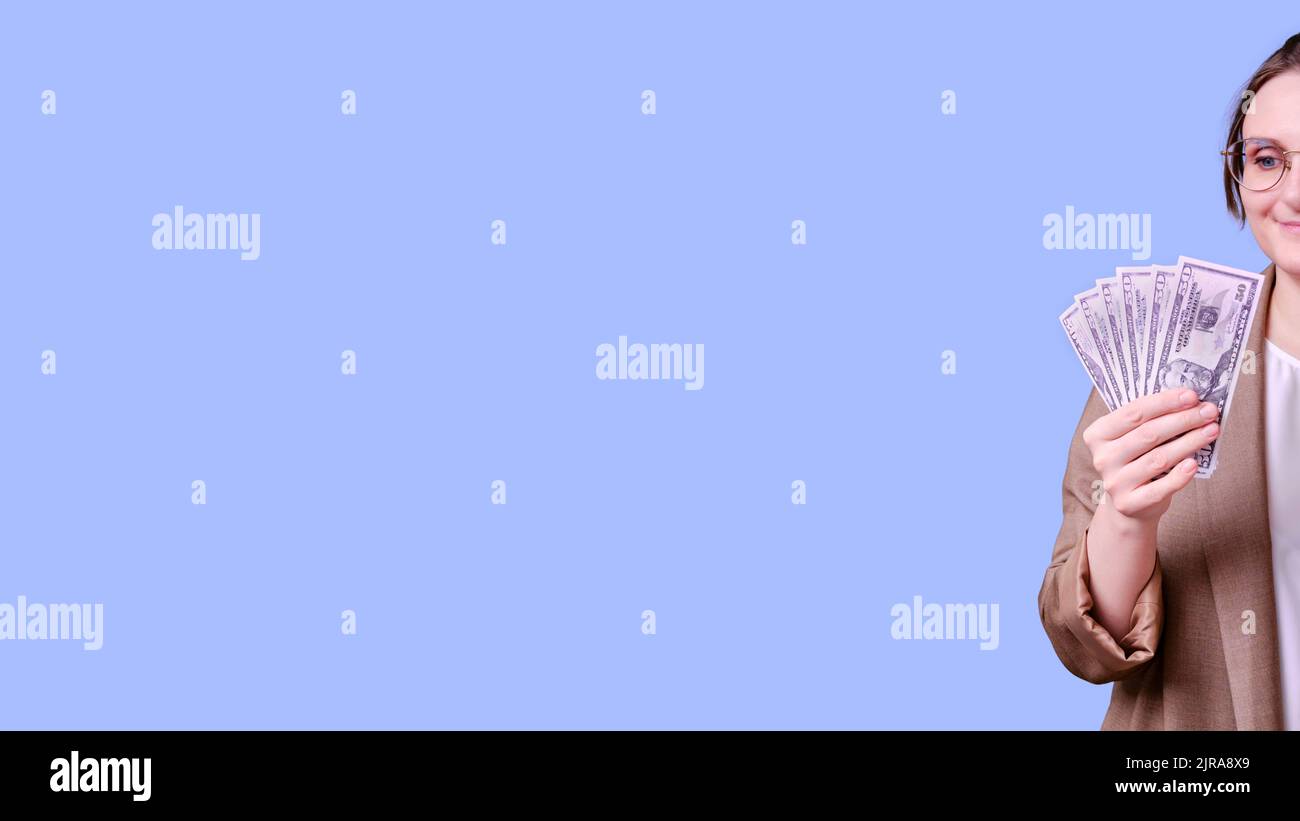 Smiling woman teacher with money in us dollars on blue background ...