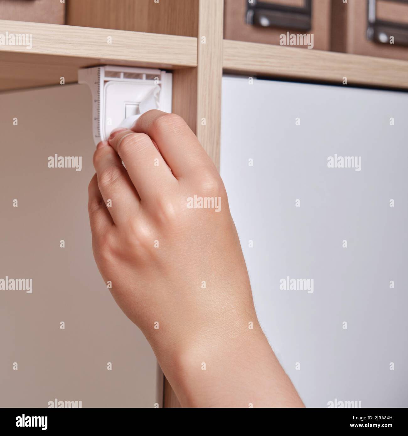 Installing a child-proof magnetic lock to protect cabinet doors and drawers of home furniture ...