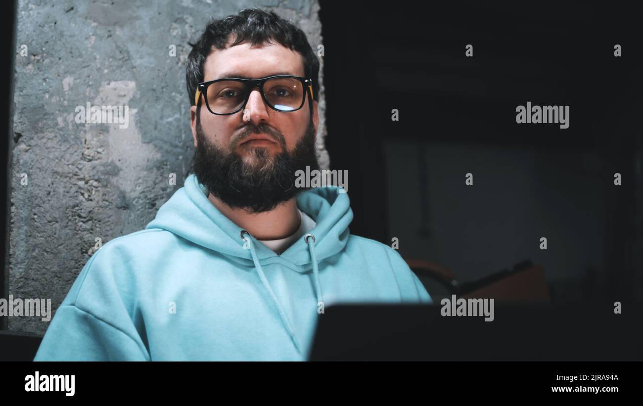 Sad Programmer Looking At The Camera While Sitting In A Dark Bomb