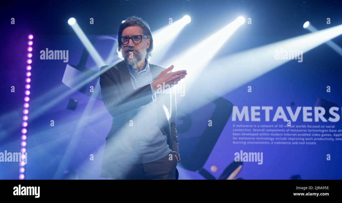 A concentrated presenter on stage speaking with the audience about the ...