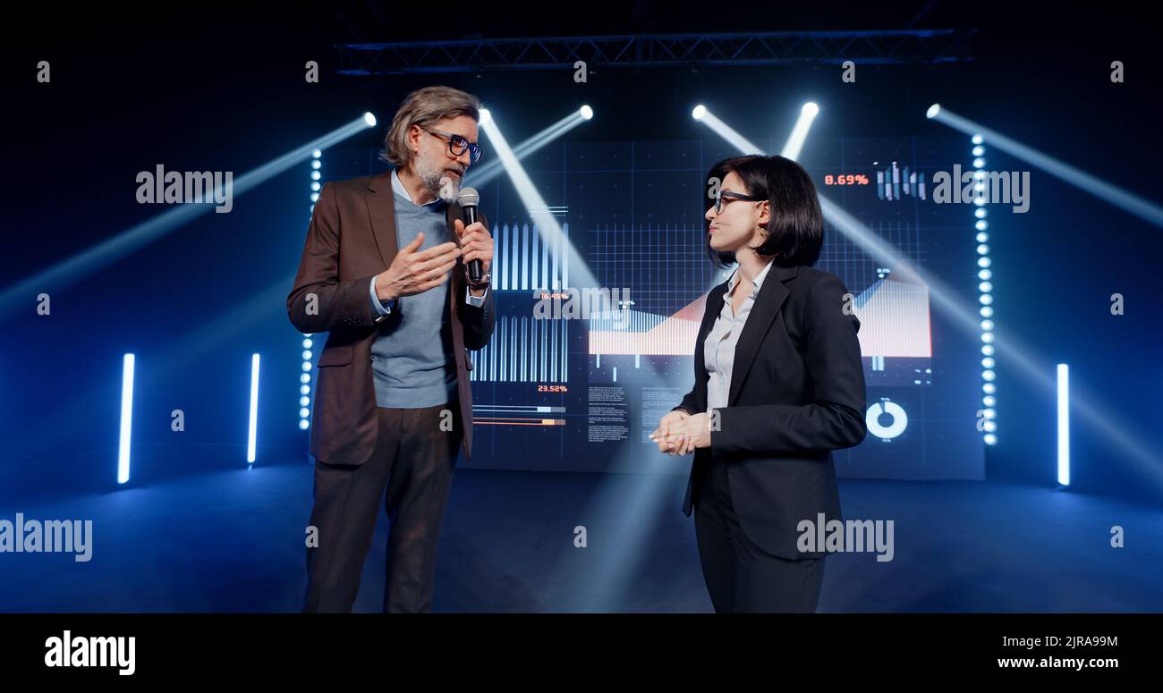 An adult businessman on the stage in casual clothes telling the female ...