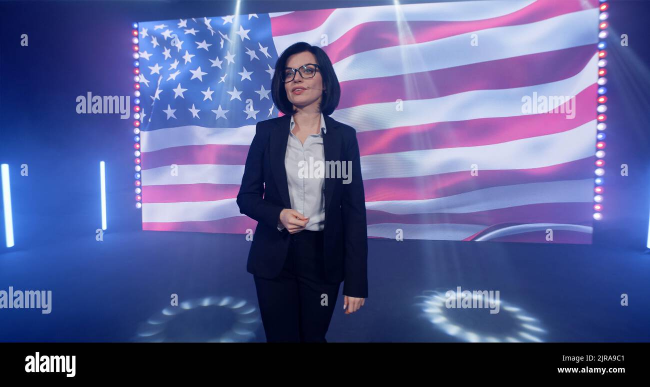 Female presenter in suit on stage talking about the latest political ...