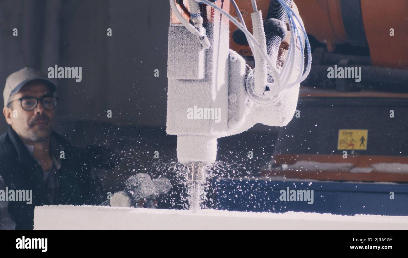 Craftsman in cap and glasses using remote control system and blowing ...