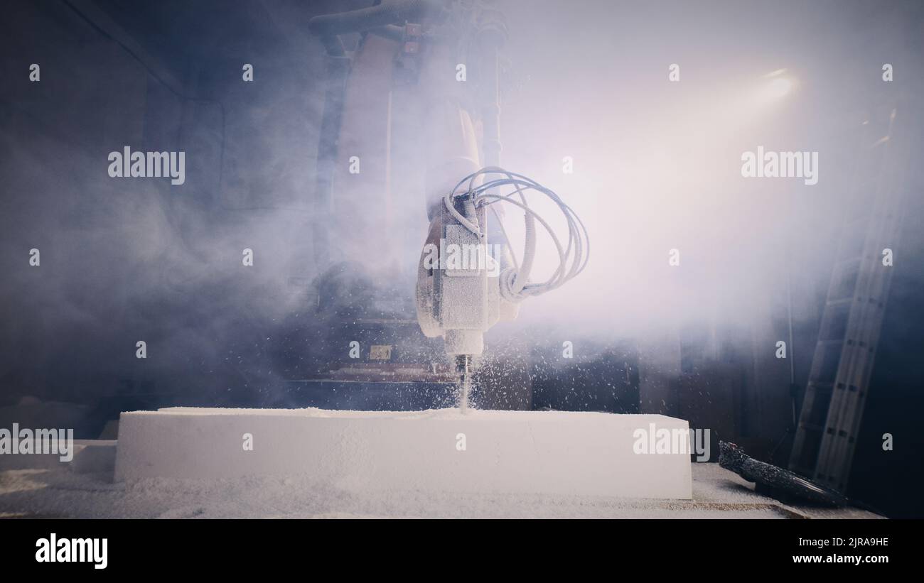 Time lapse of robotic arm milling machine cutting block of polystyrene ...