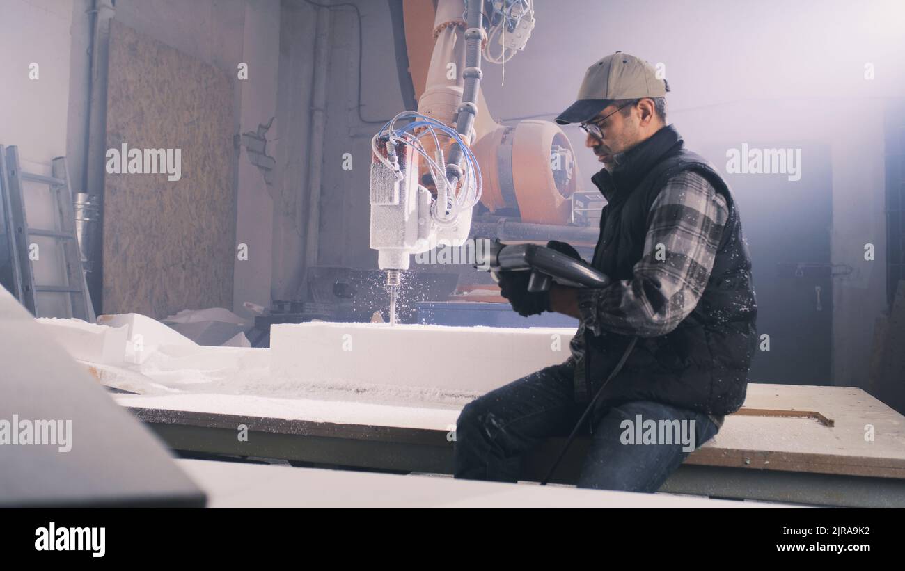 Middle aged male worker using remote control system and blowing off ...