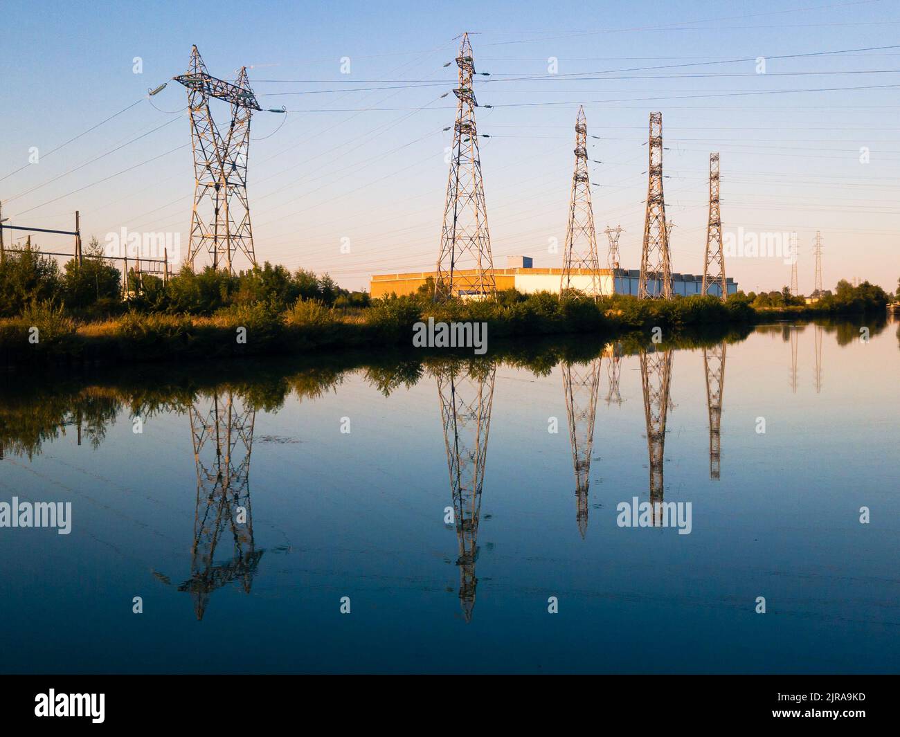 A row of metallic transmission towers of various shapes reflecting in ...