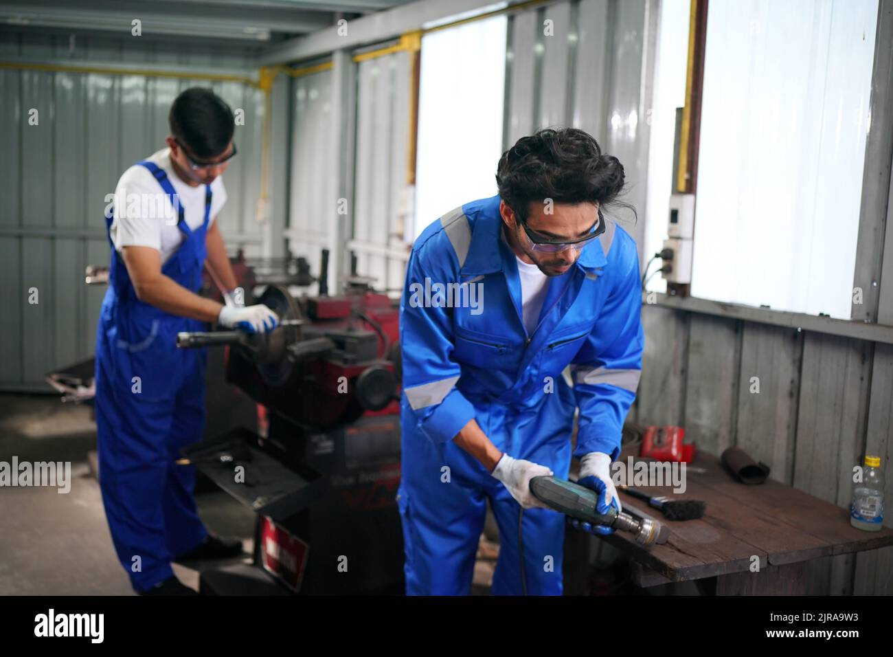 Workers changing and repair part of wheels at the car service Stock ...