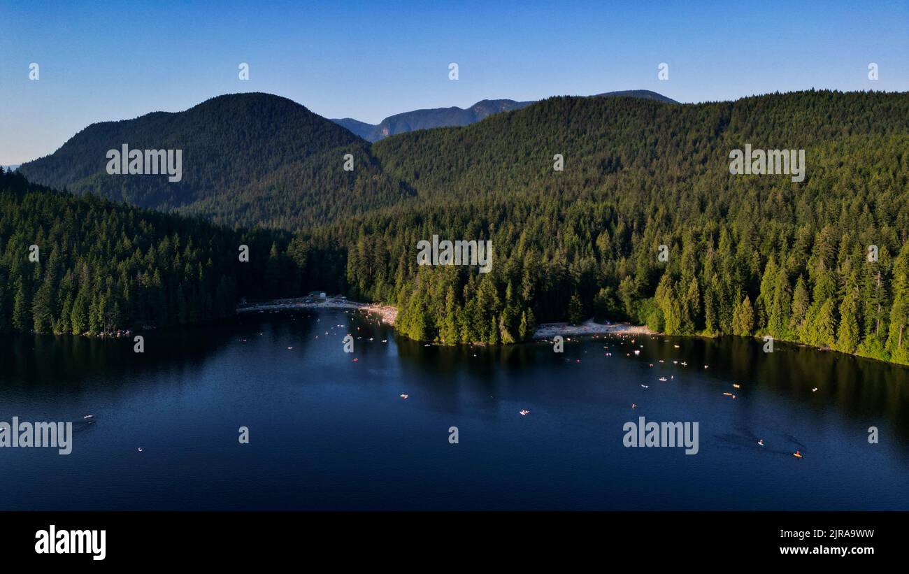 A beautiful view of Sasamat Lake surrounded by dense trees in Port ...