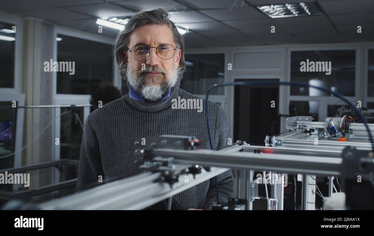 Bearded middle aged male engineer in turtleneck and glasses looking at ...