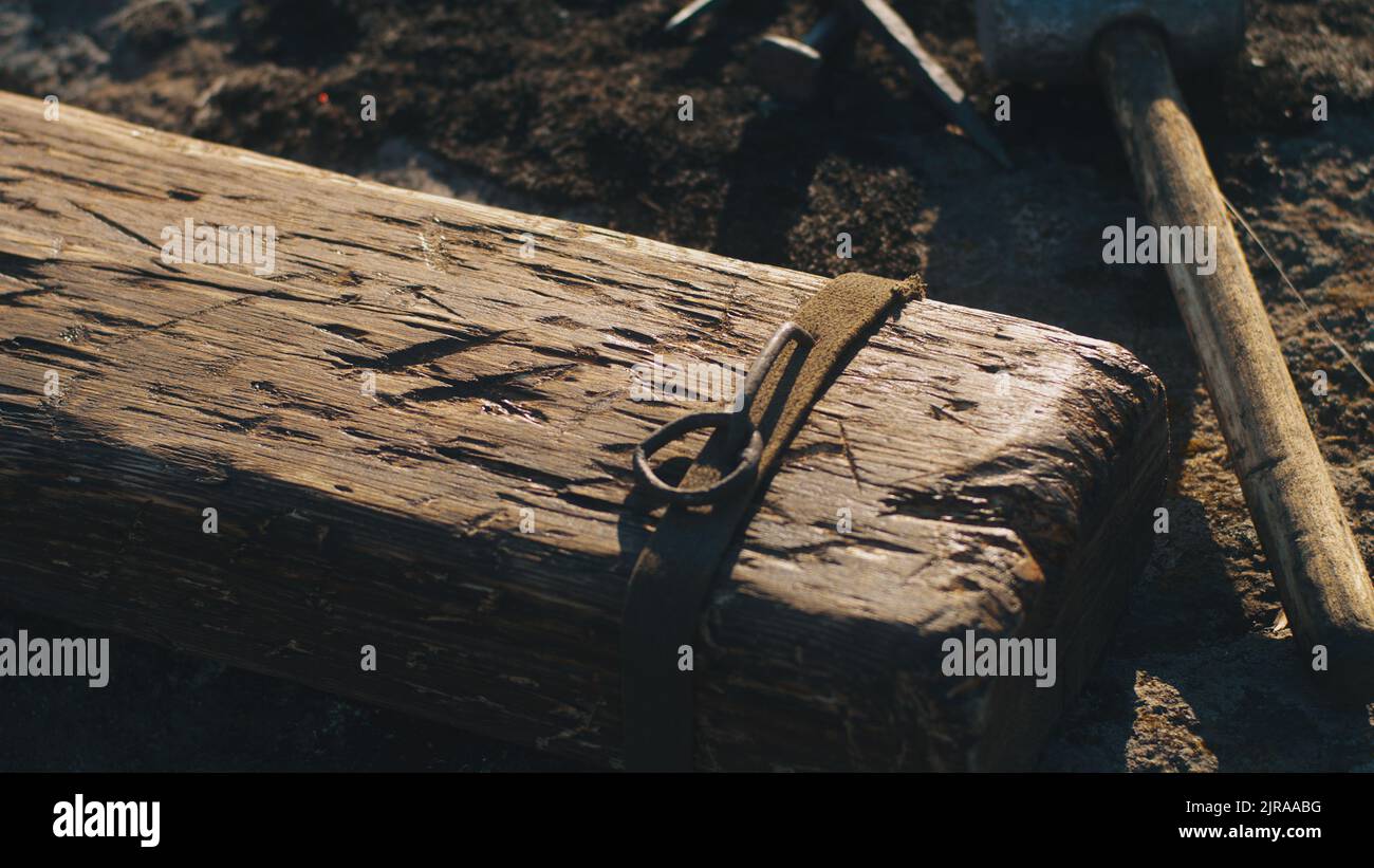 From above hammer and nails placed on ground near weathered cross ...