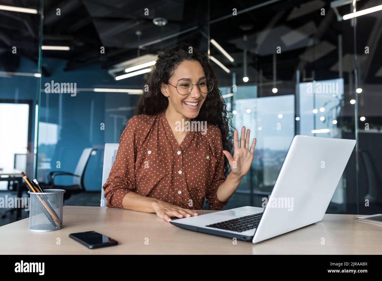 Successful and beautiful hispanic woman working inside modern office ...