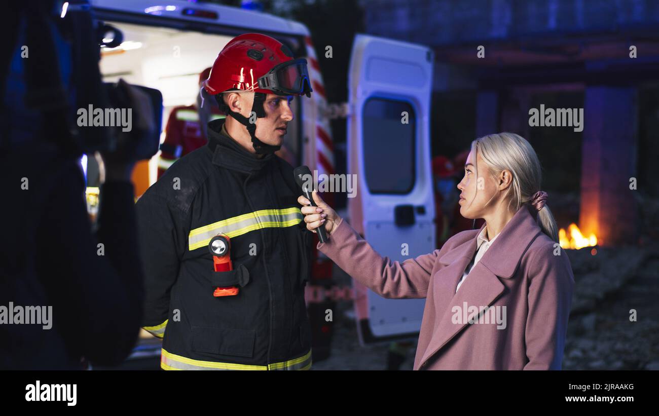 Male emergency service worker speaking while giving interview to female ...