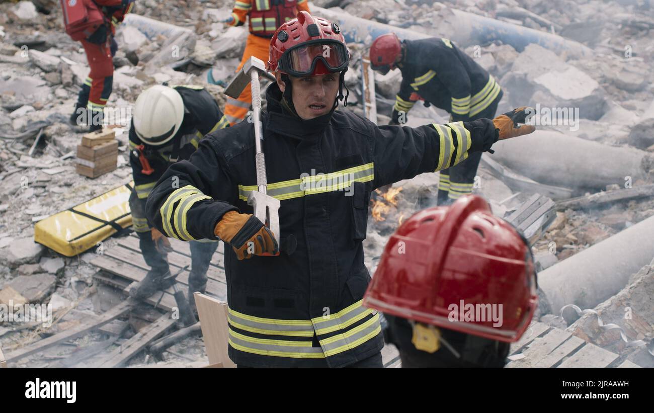 Male emergency workers in uniform talking with each other while working ...