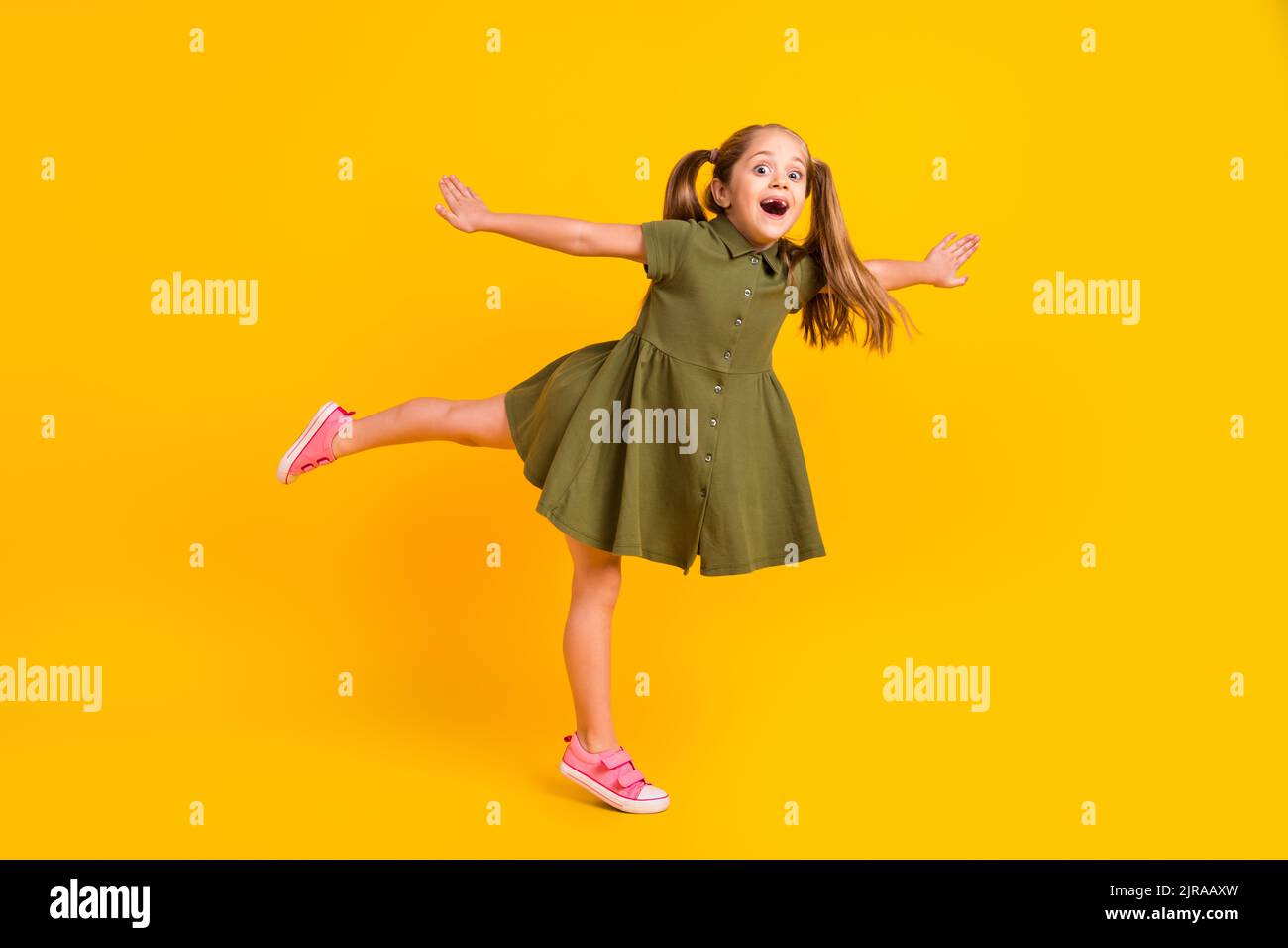 Full body photo of overjoyed positive girl stand one leg tip toe ...