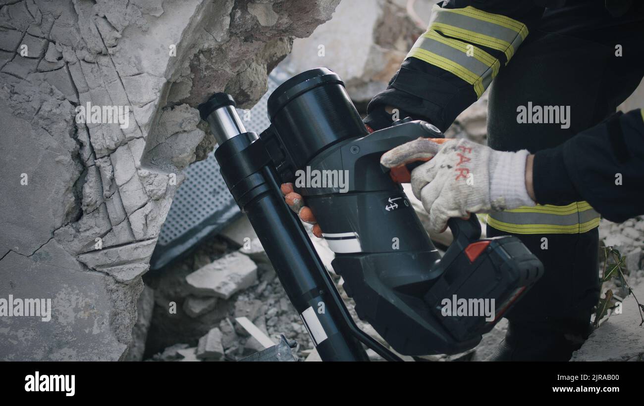 Unrecognizable emergency service worker in uniform and gloves using ...