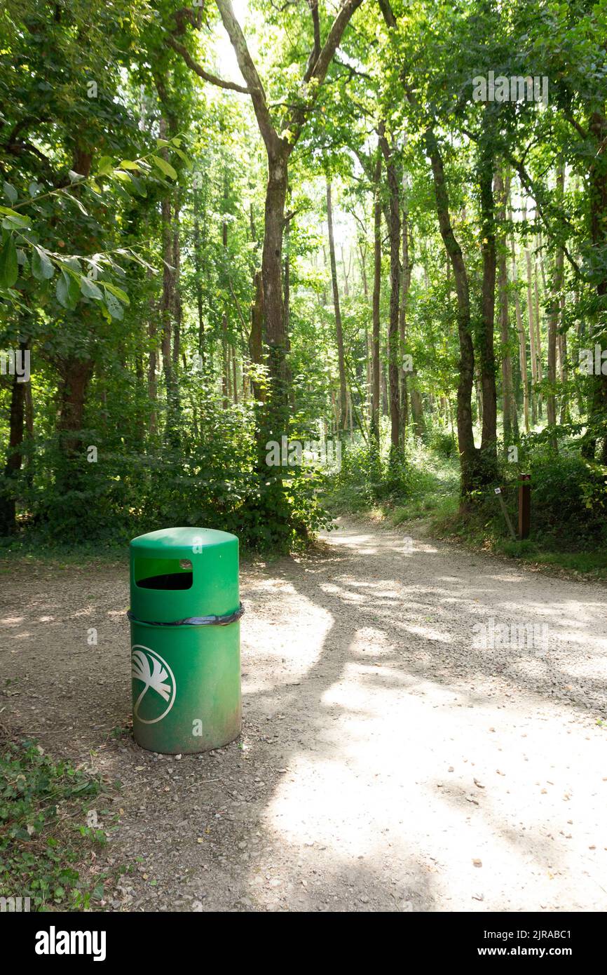 A view of a eviromentally friendly rubbish bin in a open public forest ...