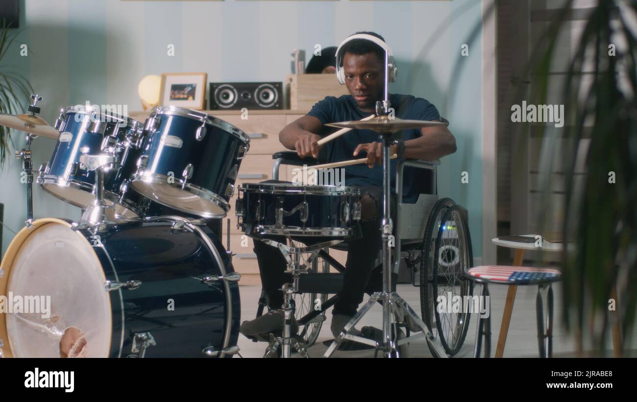 African American guy with disability listening to music in wireless ...