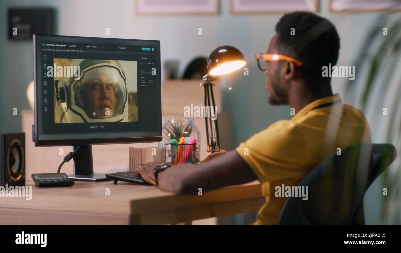 Black man using software on modern computer to edit photo in editing ...