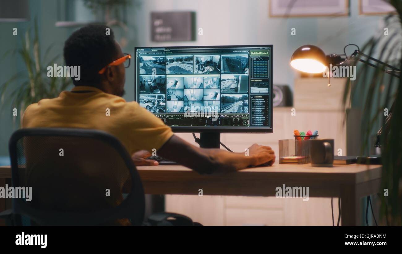 African American male security worker watching video from surveillance ...