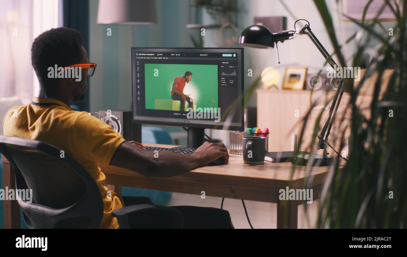 Back view of African American man using software on computer to create ...