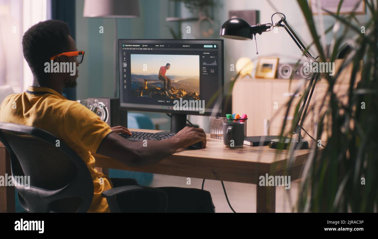 Back view of African American man using software on computer to create ...