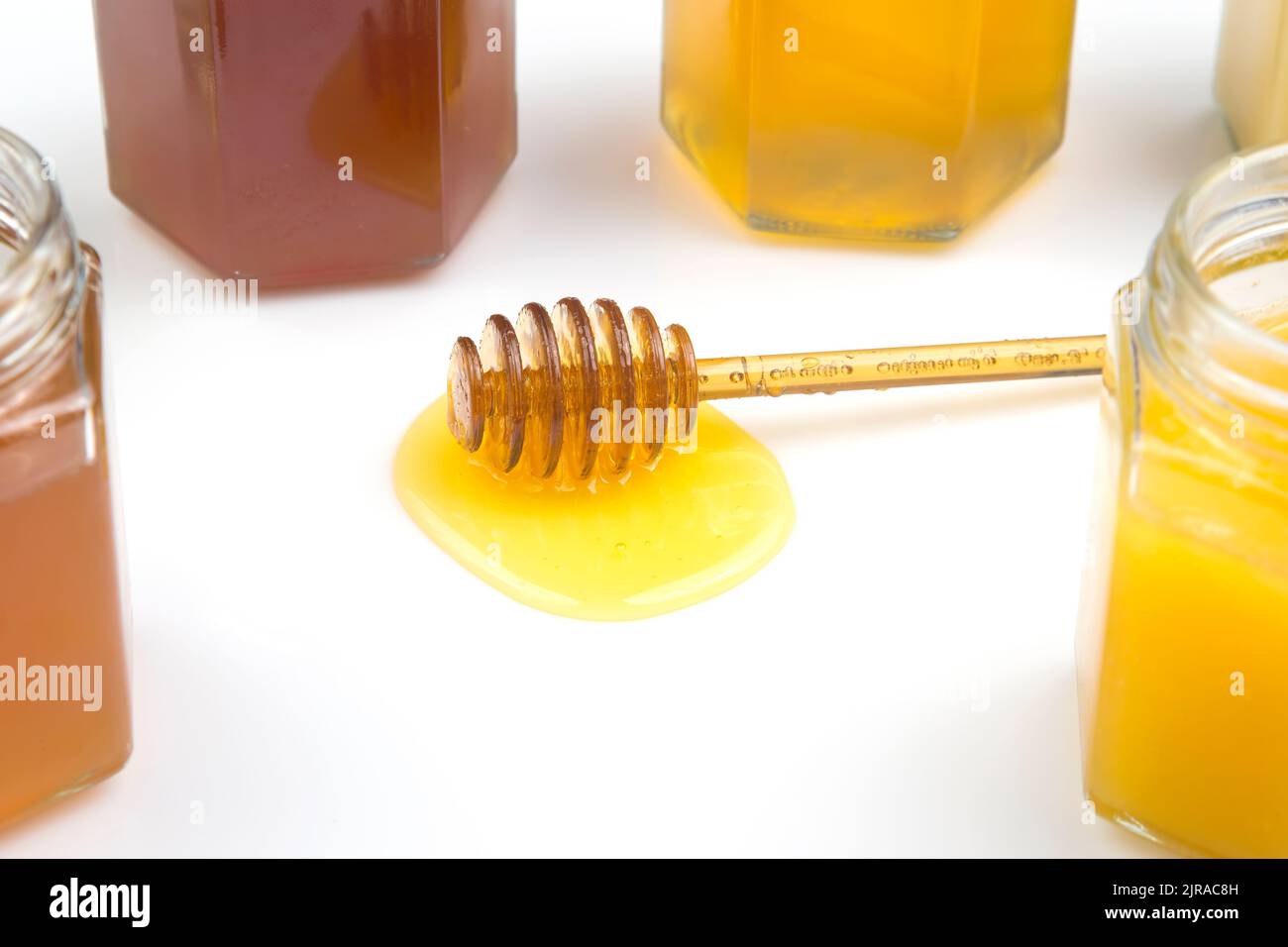 spoon with fresh honey and pollen on the background of jars with ...