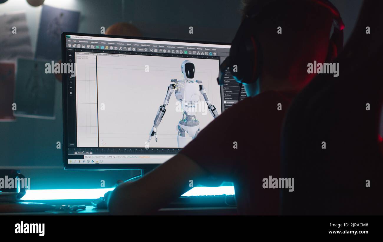 Anonymous teenager in headphones making 3D model of robot on computer ...