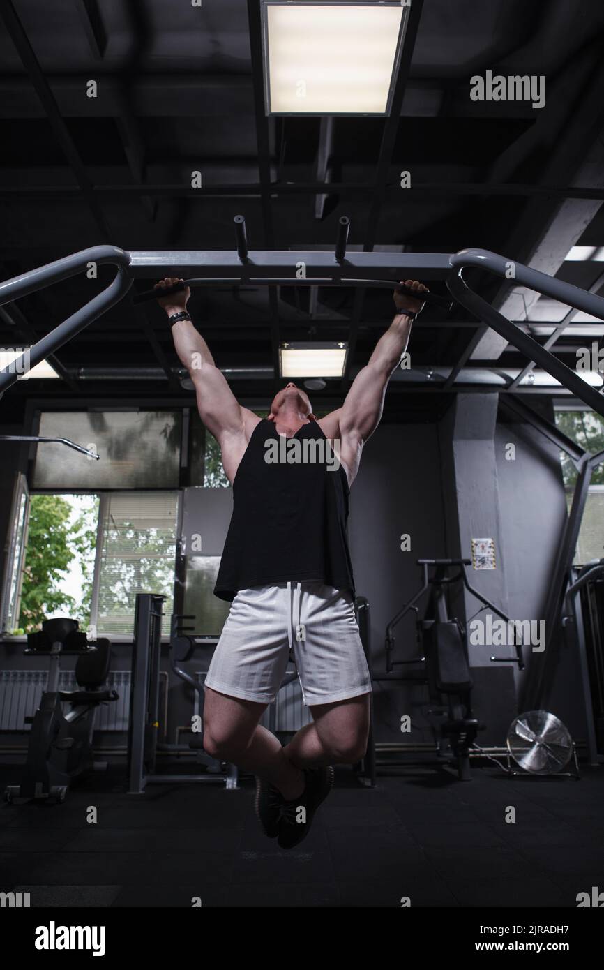 Vertical shot of a bodybuilder doing pull ups Stock Photo - Alamy
