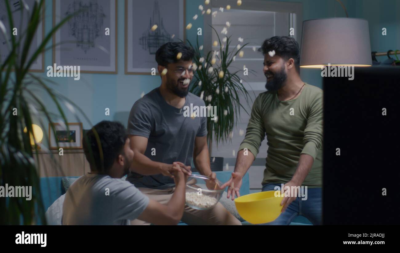 Excited Indian Men Screaming And Throwing Popcorn Then Giving High Five And Discussing Goal