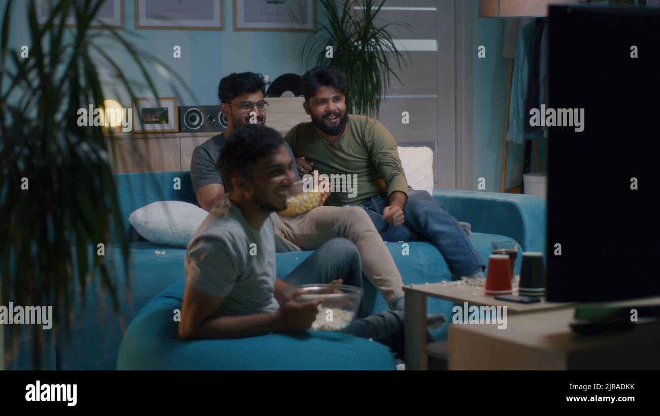 Happy Indian male fans with popcorn celebrating and discussing goal ...