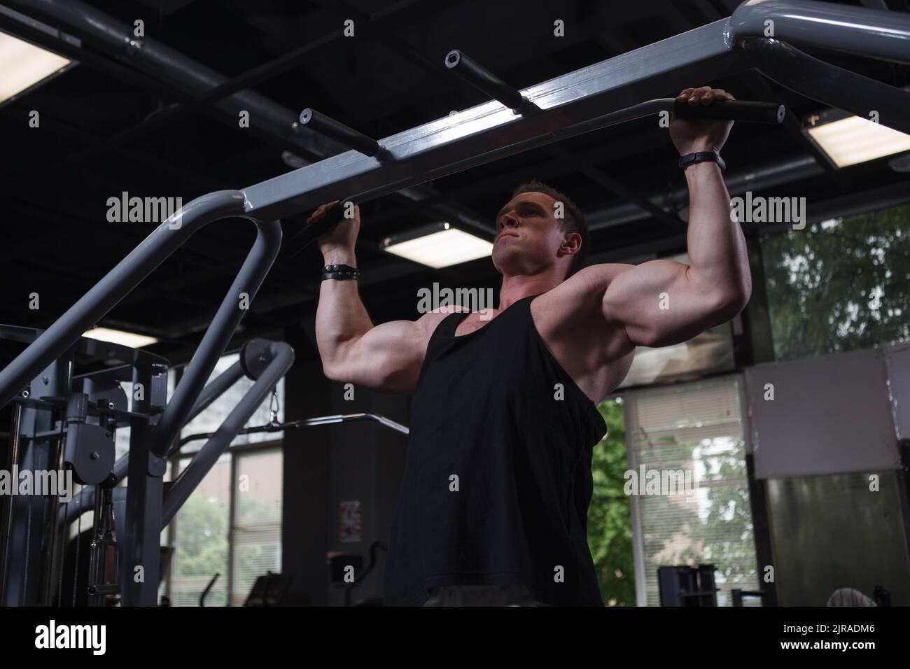Strong muscular man doing pull ups at the gym Stock Photo - Alamy