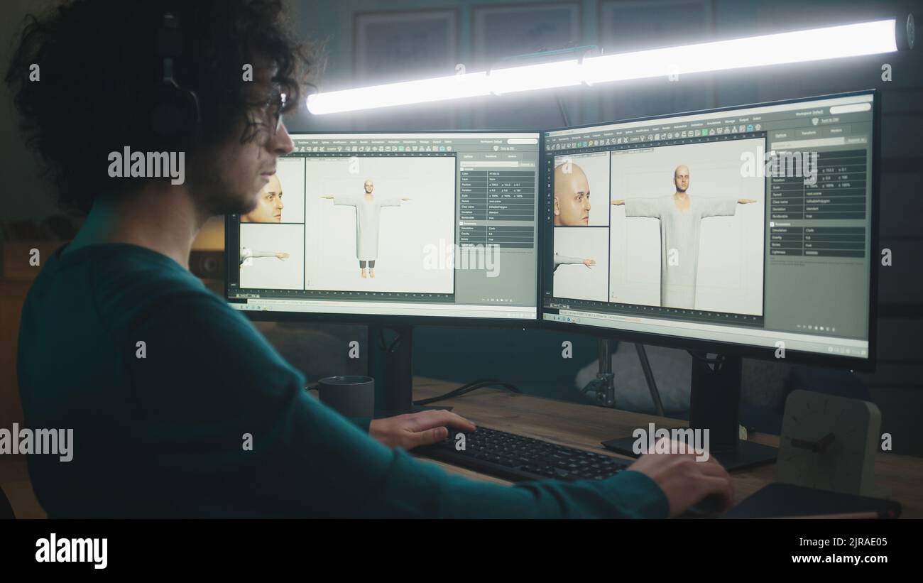 Man in glasses creating 3D human on computer while working on remote project at night at home ...