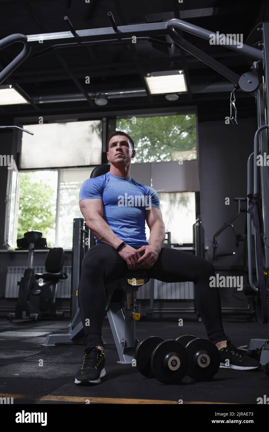 Vertical full length shot of a bodybuilder resting after exercising ...