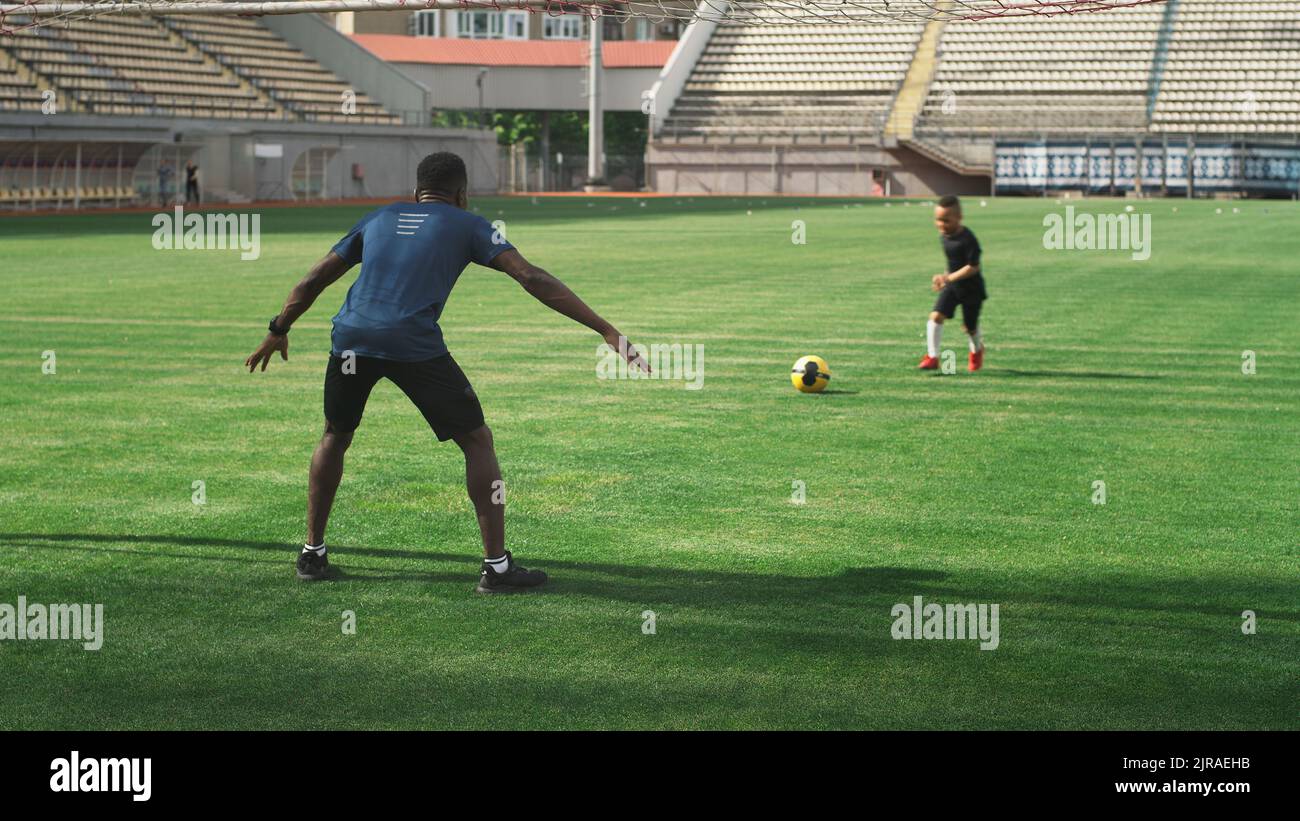 African American man trying to catch ball shot by mixed race boy while ...