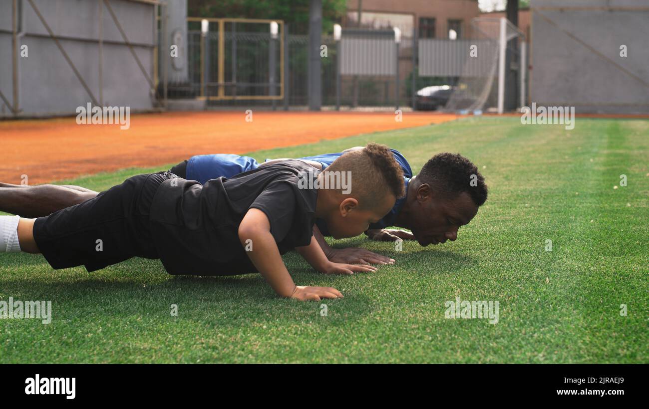 Pan around view of black coach and mixed race boy in sportswear doing ...