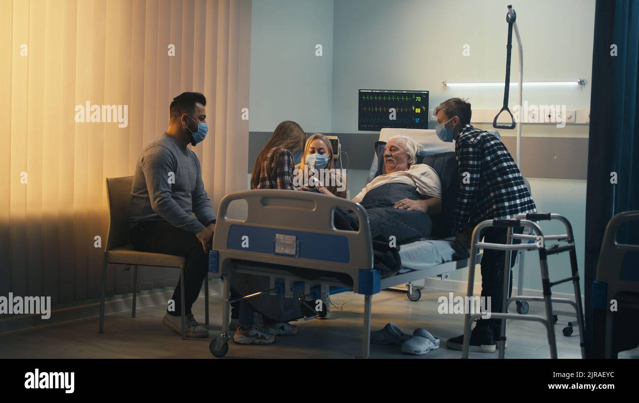 Family in masks entering hospital ward after medical practitioner and ...