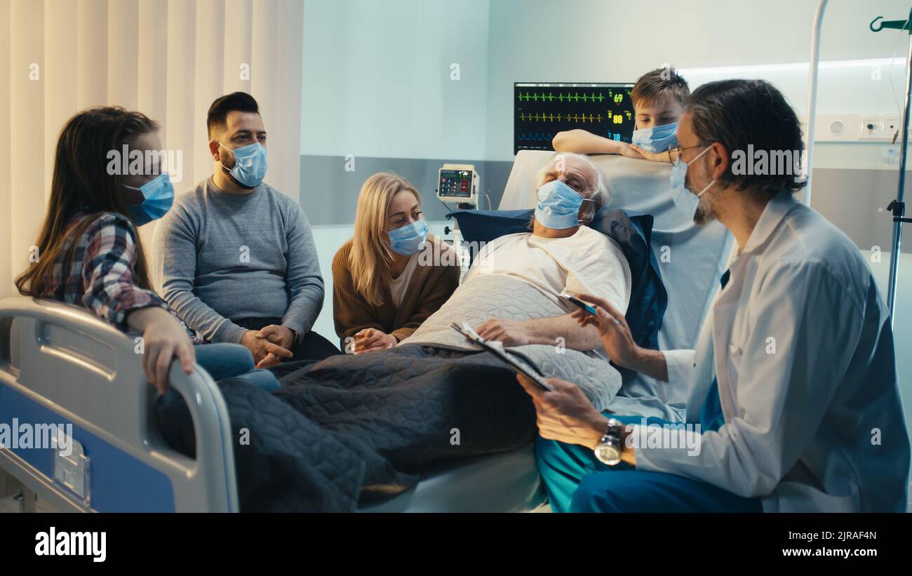 Middle aged medical practitioner in mask talking with aged male patient ...