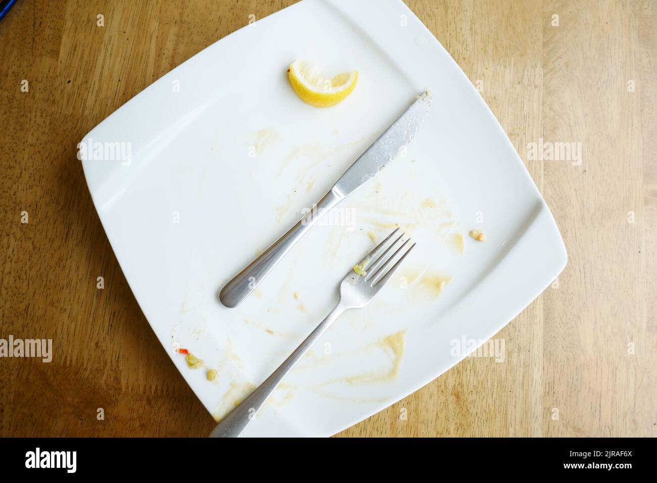 Empty plate after eating on table Stock Photo - Alamy