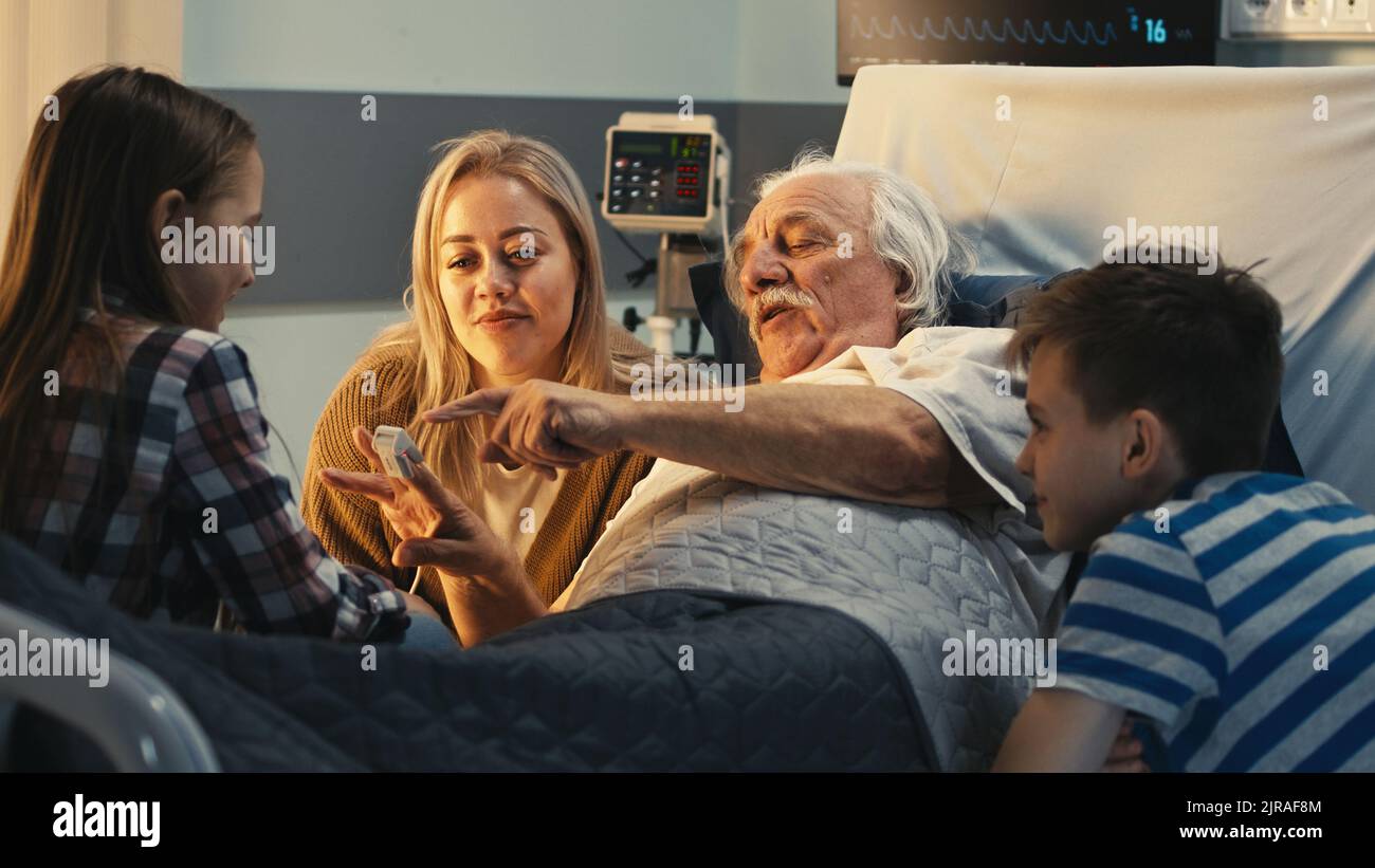 Positive adult woman and kids talking and embracing elderly man while ...