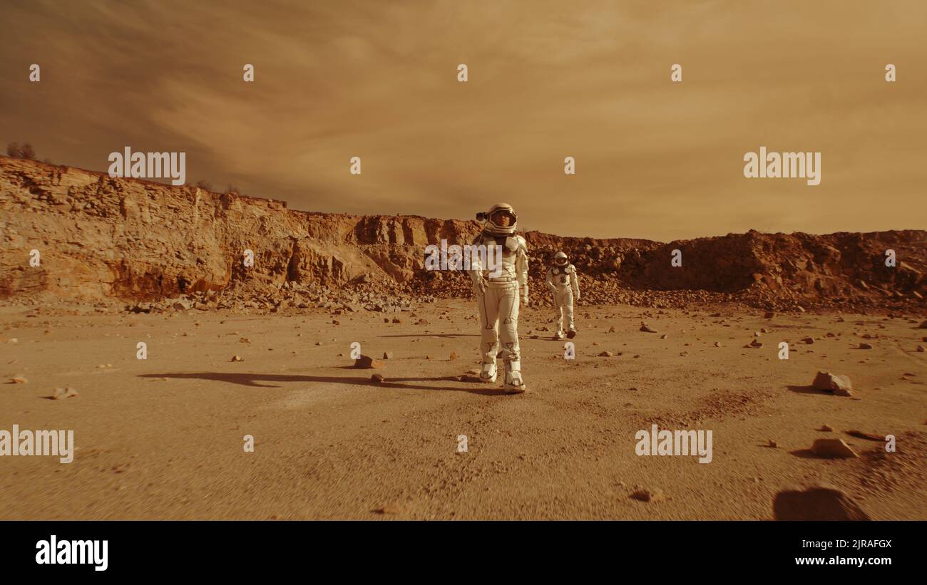 Pan around view of woman in spacesuit looking away and observing rocky ...
