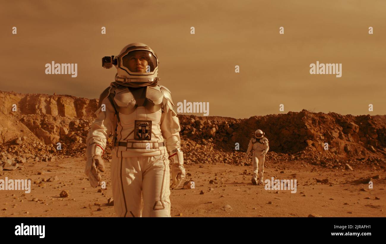 Tracking shot of woman in spacesuit looking around and searching for base location while ...