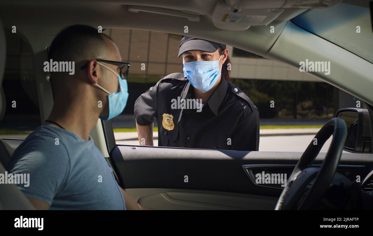 Woman in police uniform asking man to put on mask and talking while ... Woman in police uniform asking man to put on mask and talking while ...