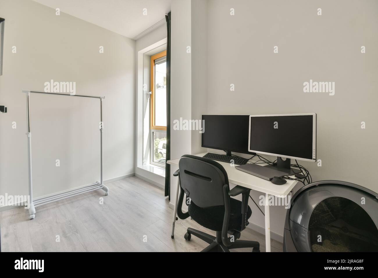 Comfortable chair placed near desk with computer monitors and ...