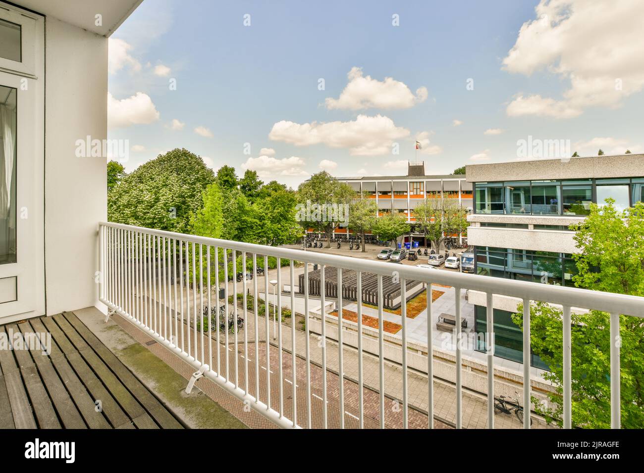 Front view of buildings and cars from small balcony with railings Stock ...