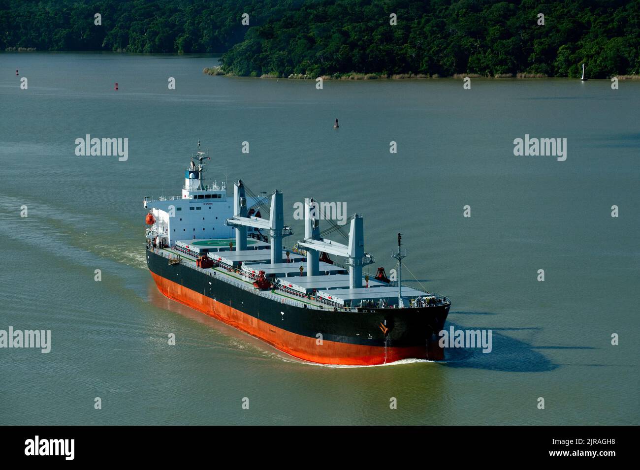 Aerial view of grain cargo ship in transit crossing Gatun lake in the ...