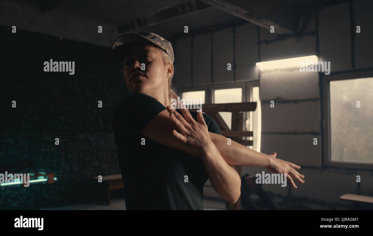 View of military woman in cap stretching neck and shoulders during ...